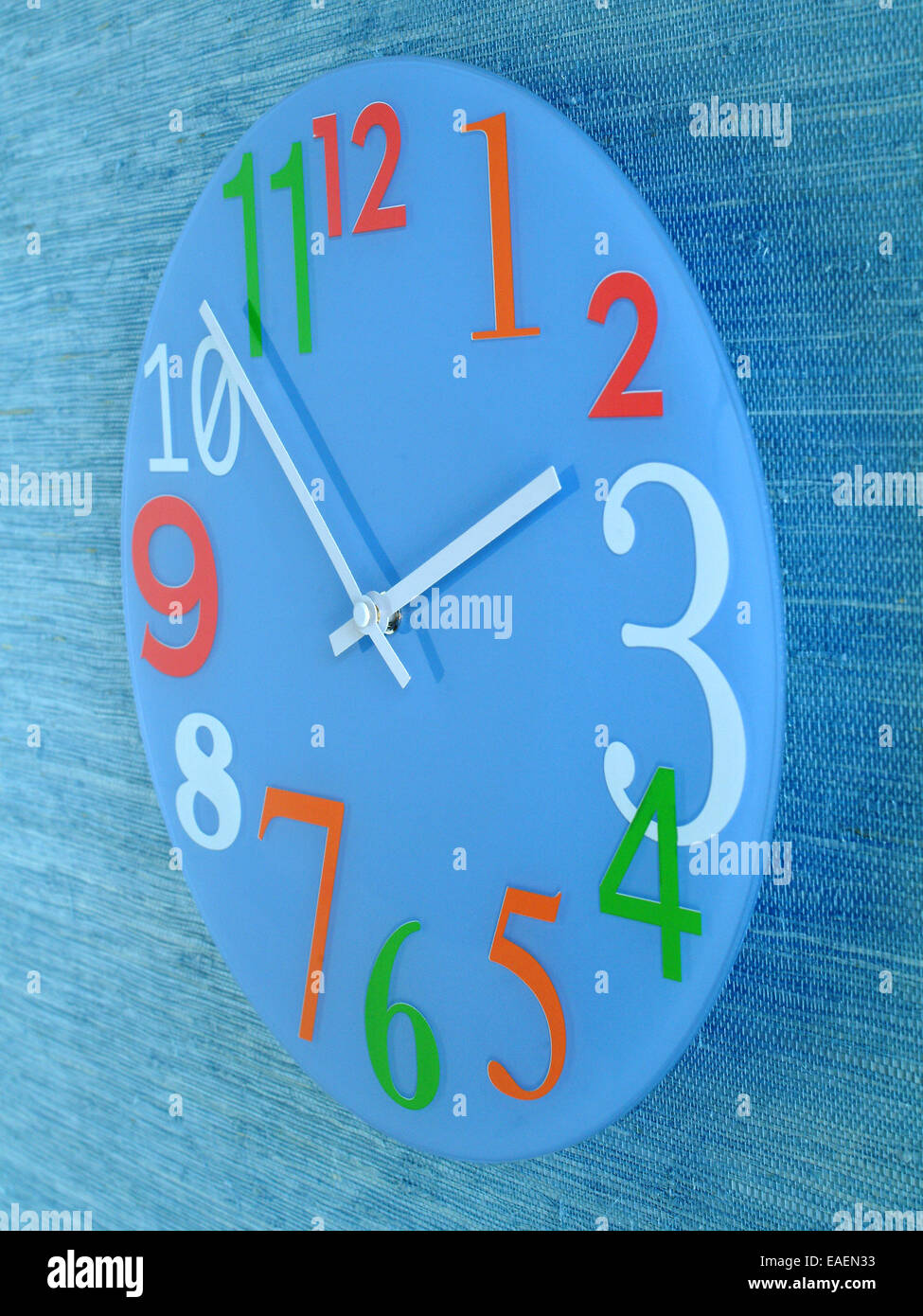 Blue wall clock with colorful numbers Stock Photo - Alamy