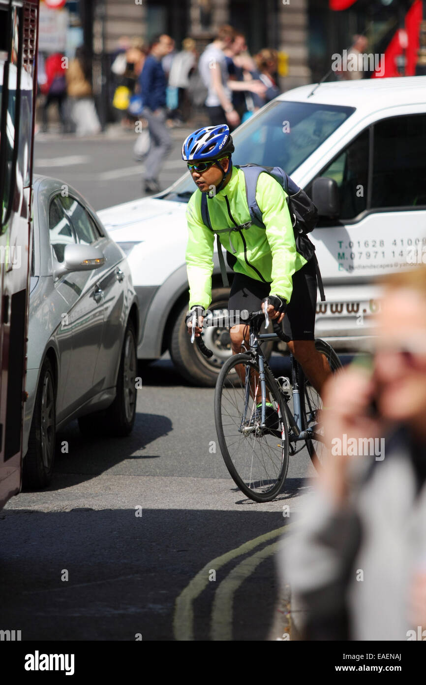 A cyclist weaving through traffic in London's Trafalgar Square Stock ...