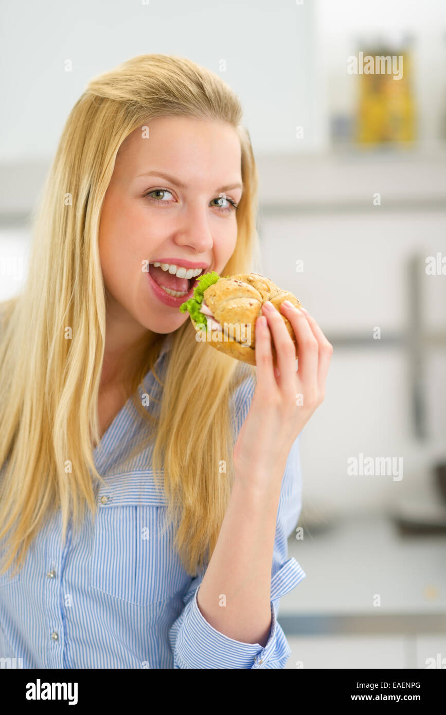 Happy young woman eating sandwich Stock Photo - Alamy