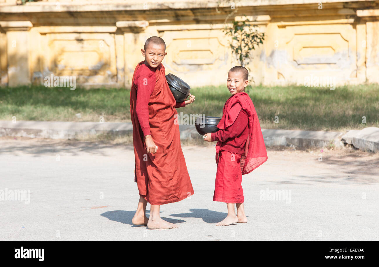 Buddhist monk and novice boy,receiving alms, near Atumashi Monastery at ...