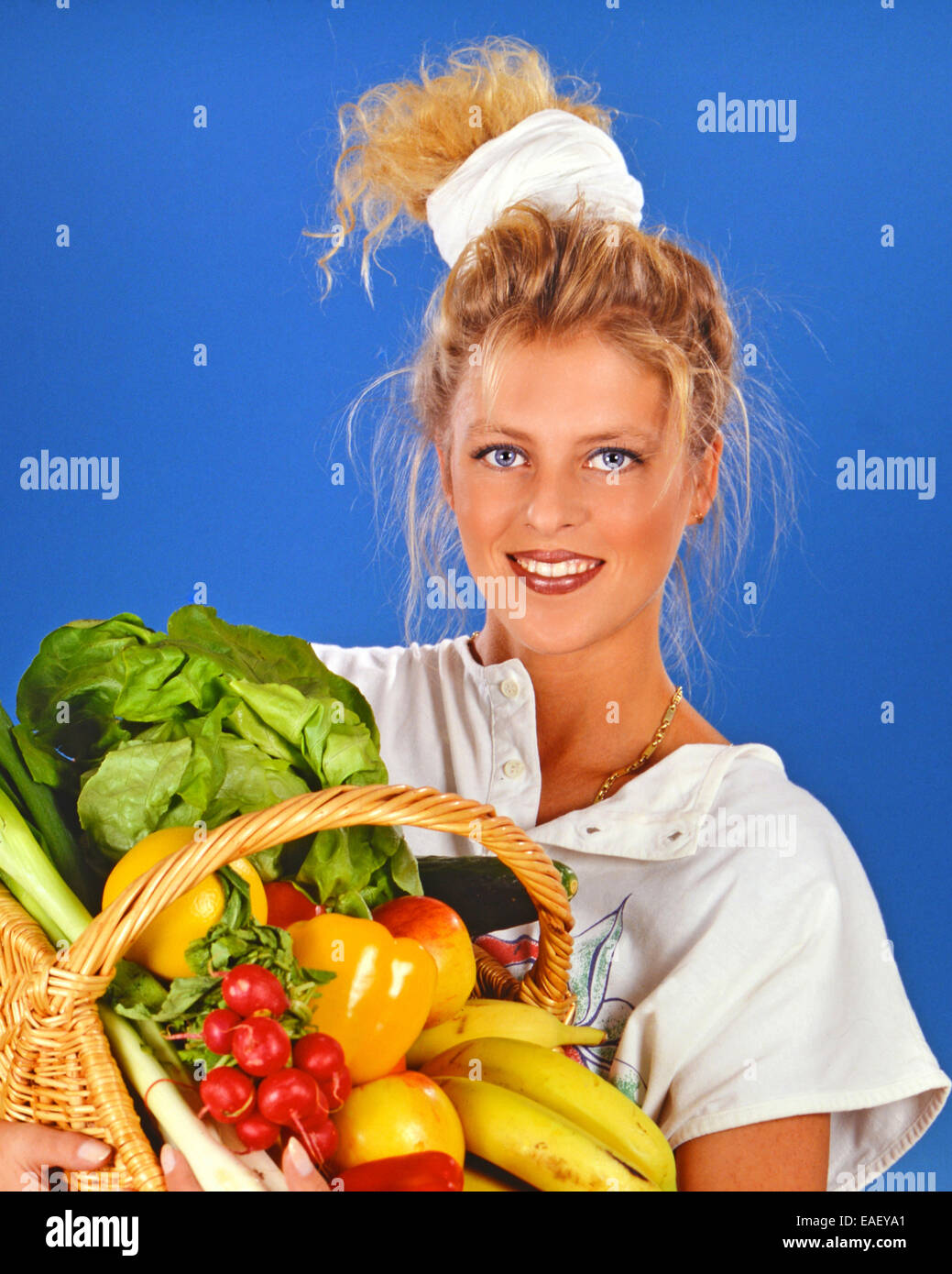 Blond woman with a basket full with Vegetables Stock Photo - Alamy