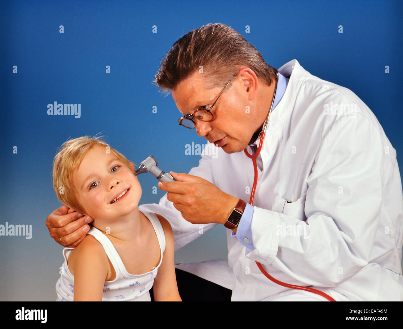 Doctor look in the ear from a boy Stock Photo - Alamy