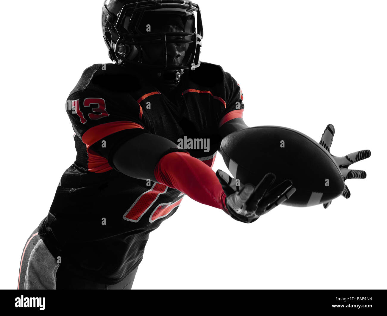 one american football player catching ball in silhouette shadow on ...