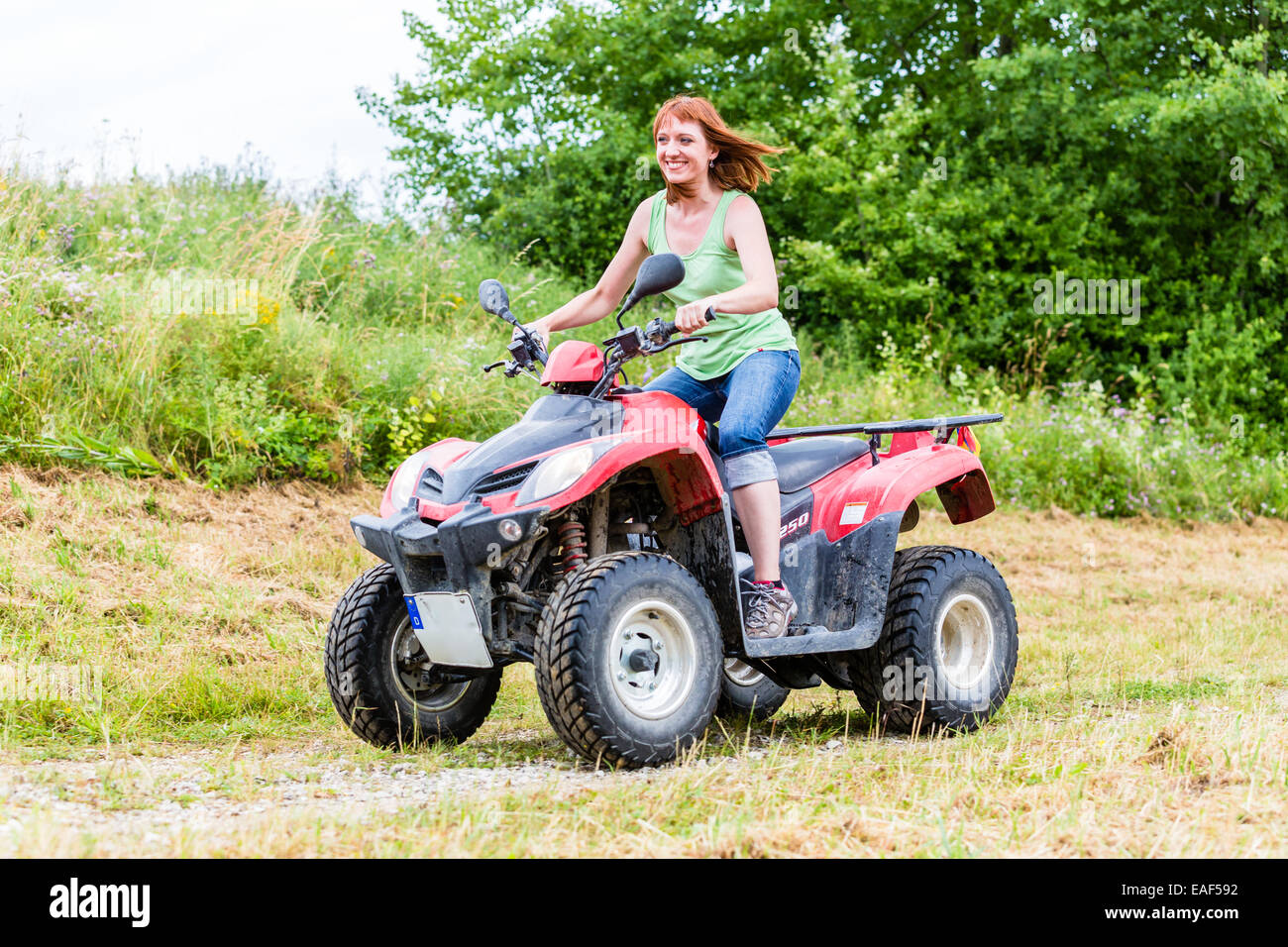 Woman driving off-road with quad bike or ATV Stock Photo - Alamy