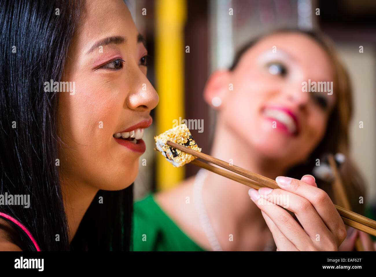 Young people eating sushi in Asian restaurant Stock Photo - Alamy