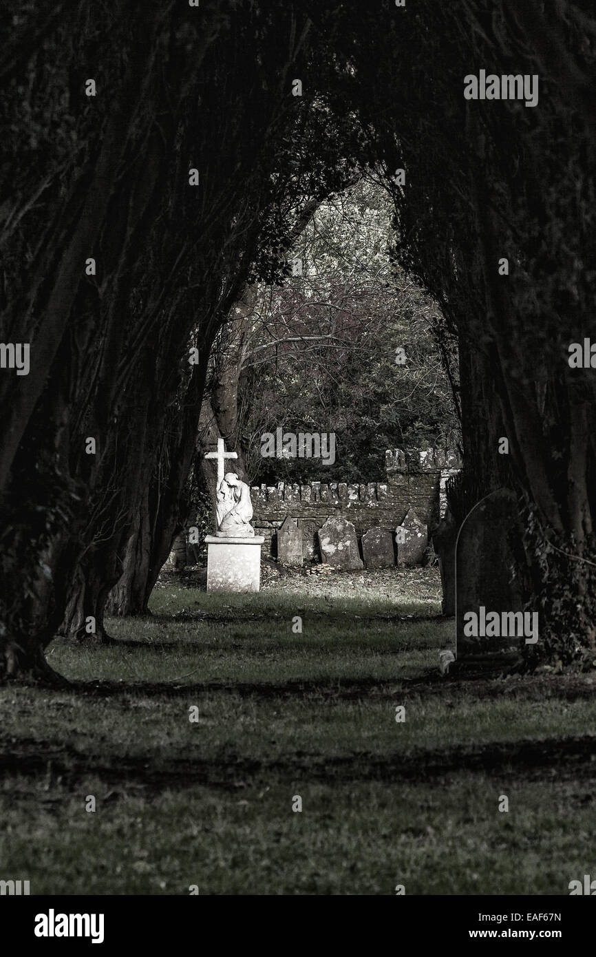 A statue with a cross in a cemetery in Corfe Castle, Dorset Stock Photo ...