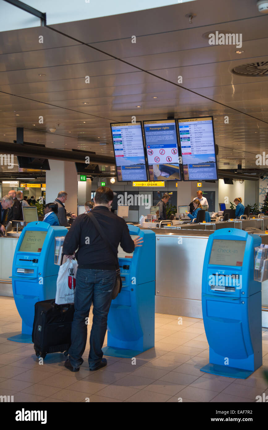 travellers at automatic check-in at schiphol airport in amsterdam ...