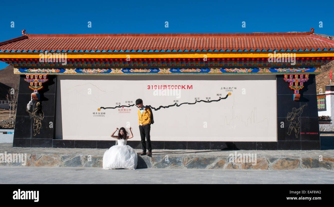 Newly-weds from Guangzhou pose at Km 5000 marker on Highway 318 ...