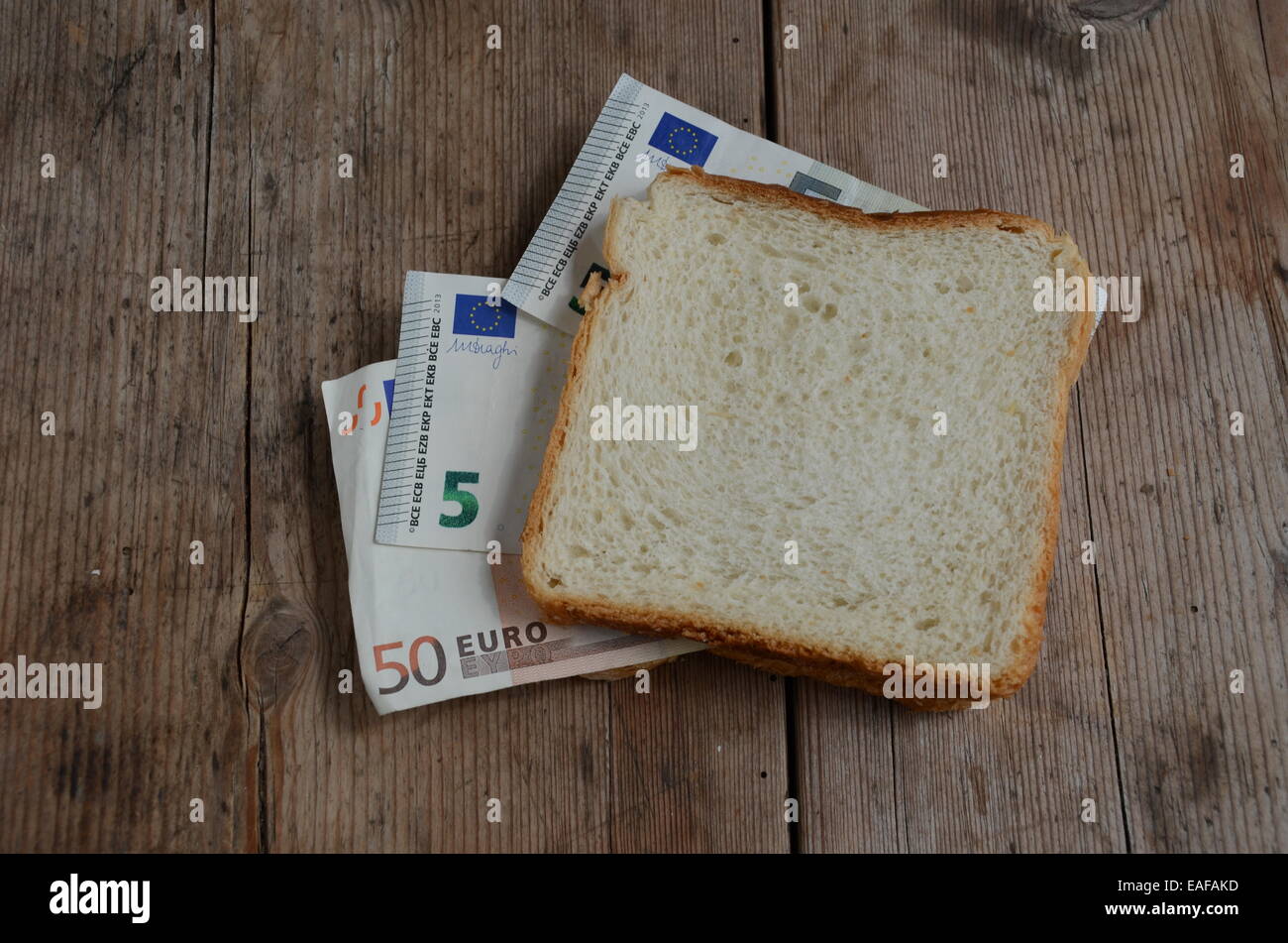 slice white bread with euro money banknotes on table Stock Photo - Alamy
