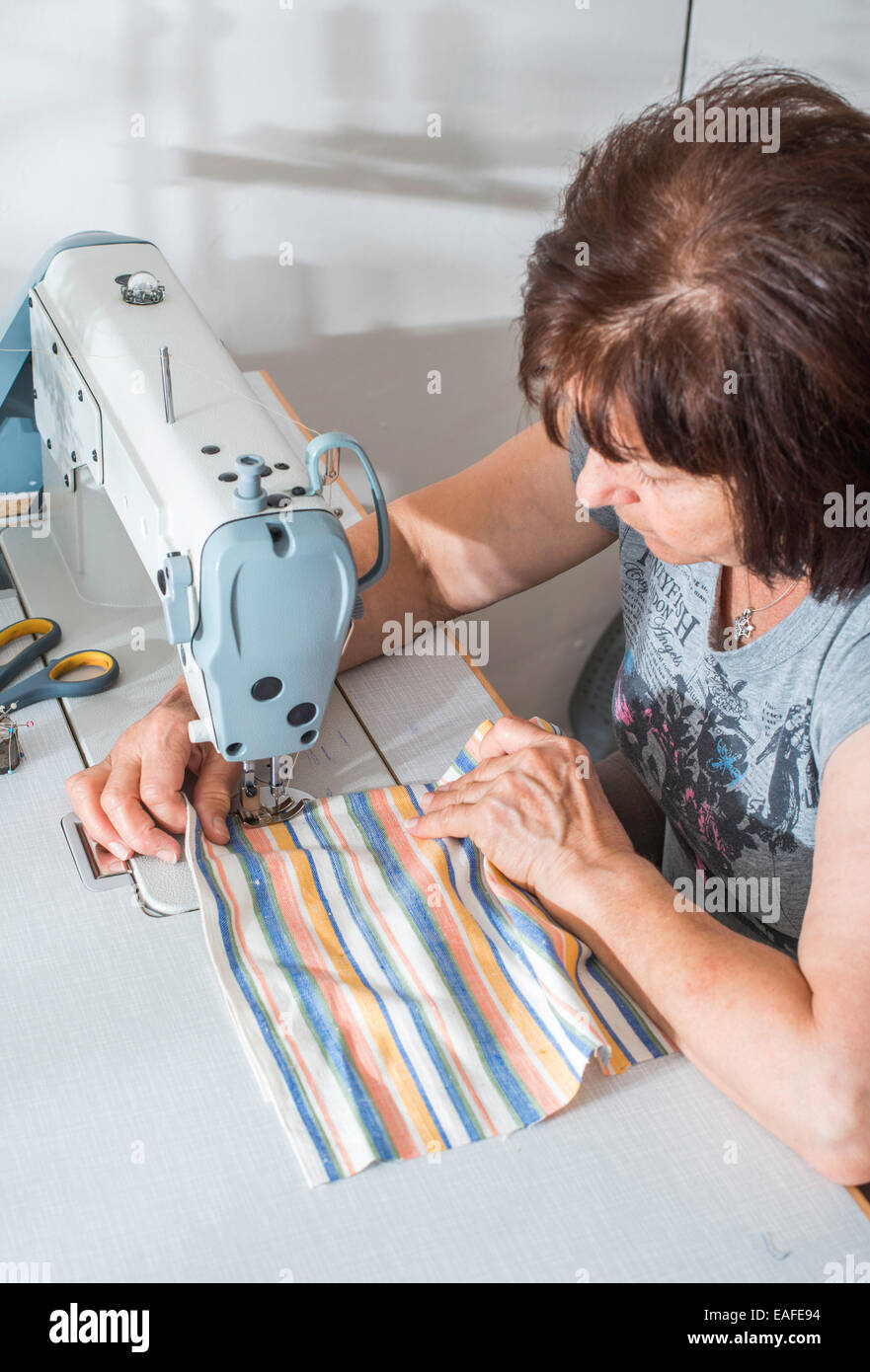 Women sew on sewing machine. White machine Stock Photo - Alamy