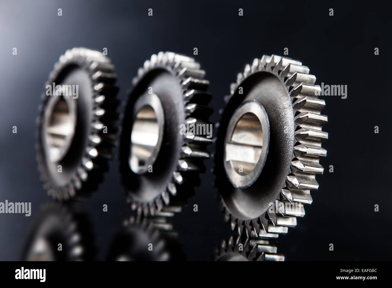 Big metal gears on glossy black background Stock Photo - Alamy