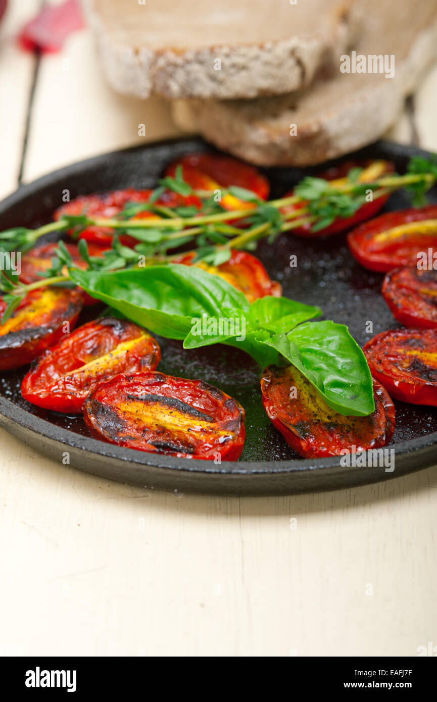 oven baked cherry tomatoes with basil and thyme on a cast iron skillet ...
