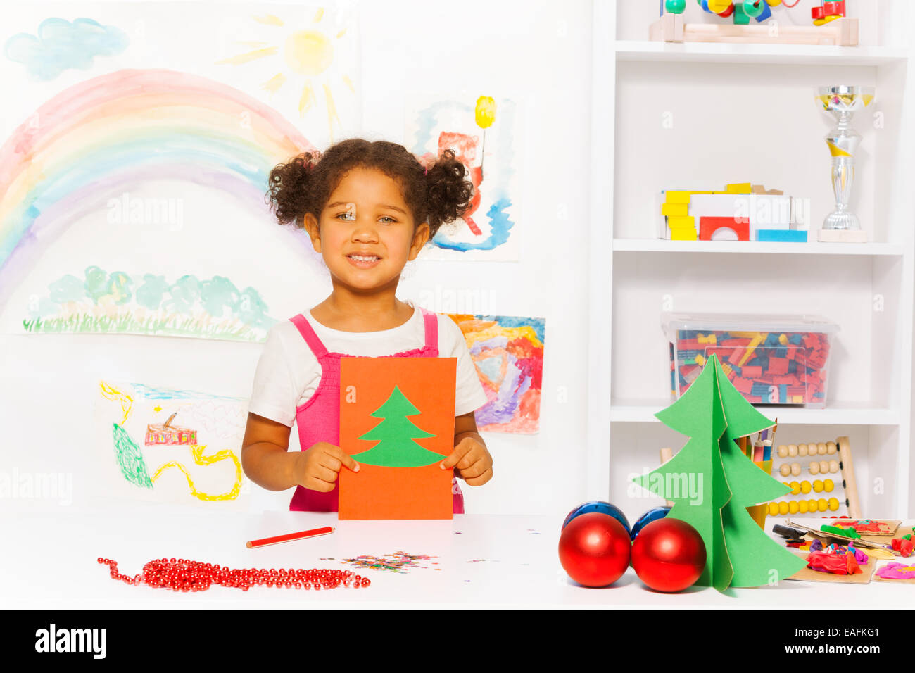 Cute girl holding carton card with Xmas tree Stock Photo - Alamy