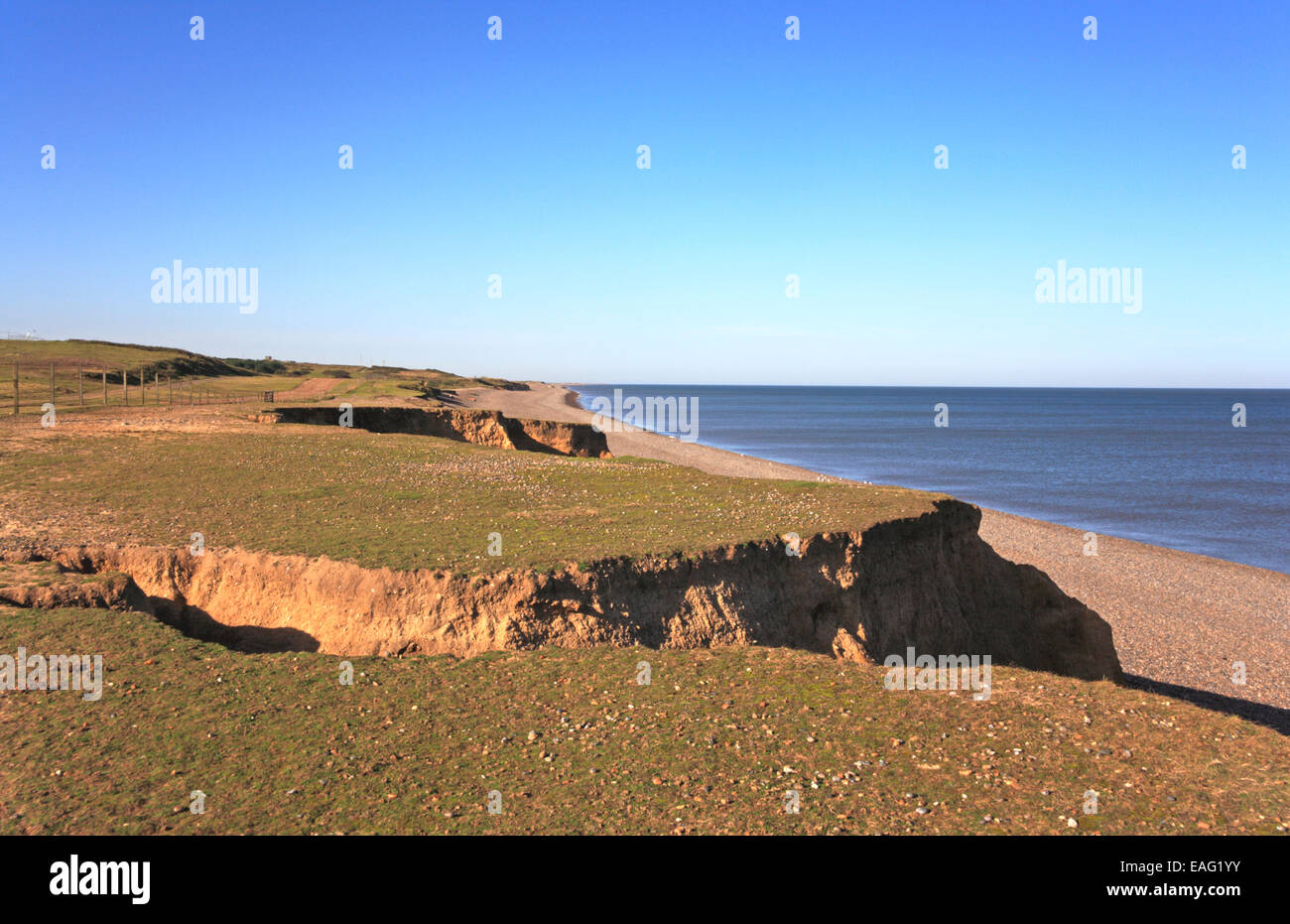 A view of low eroding cliffs behind the shingle beach at Weybourne on ...