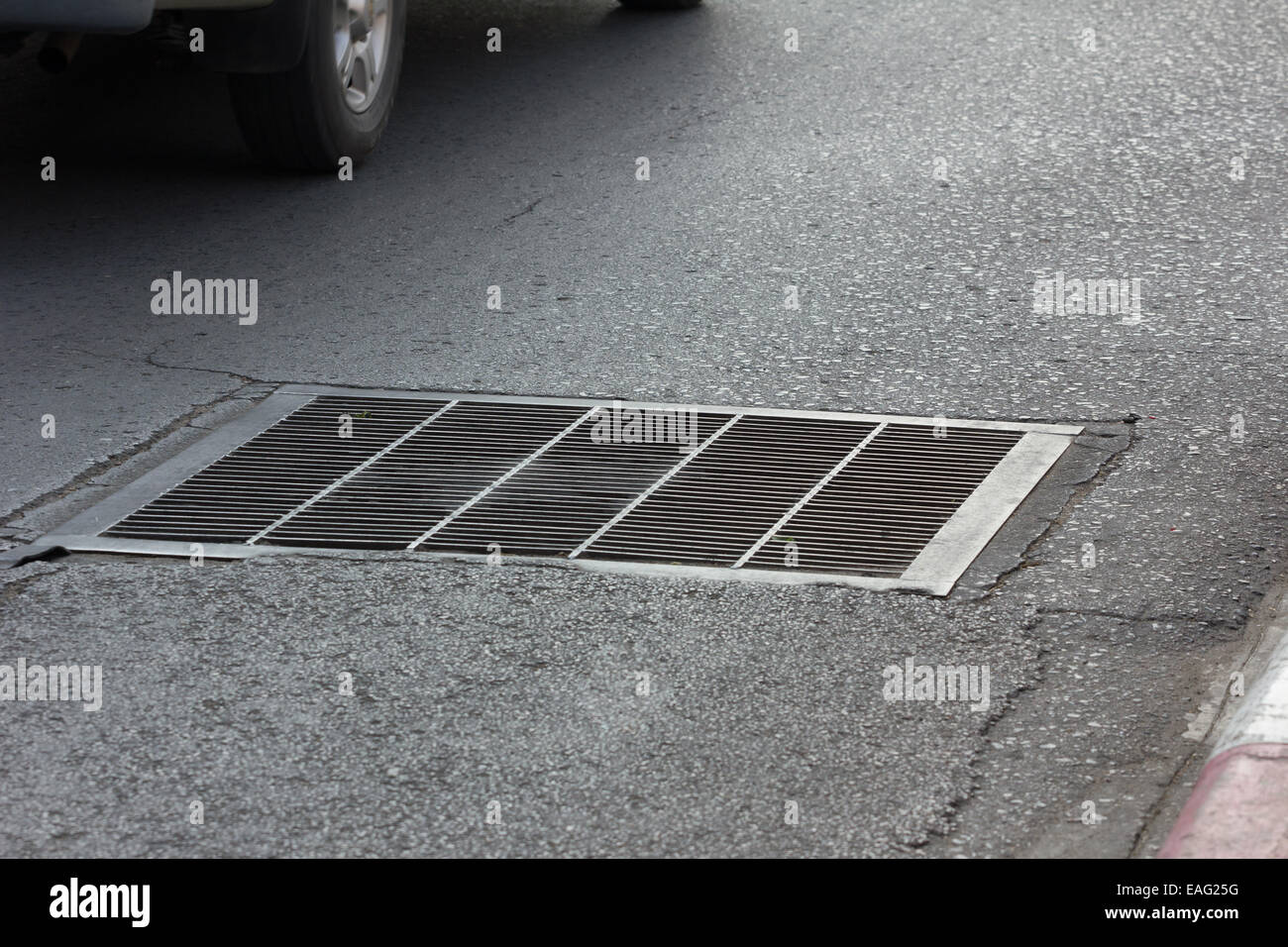 Drain grating on road in Thailand Stock Photo - Alamy