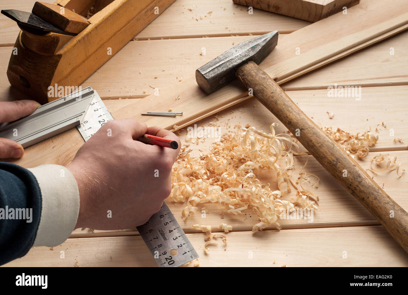 carpenter tools,hammer,meter, nails,shavings, and plane over wood table ...