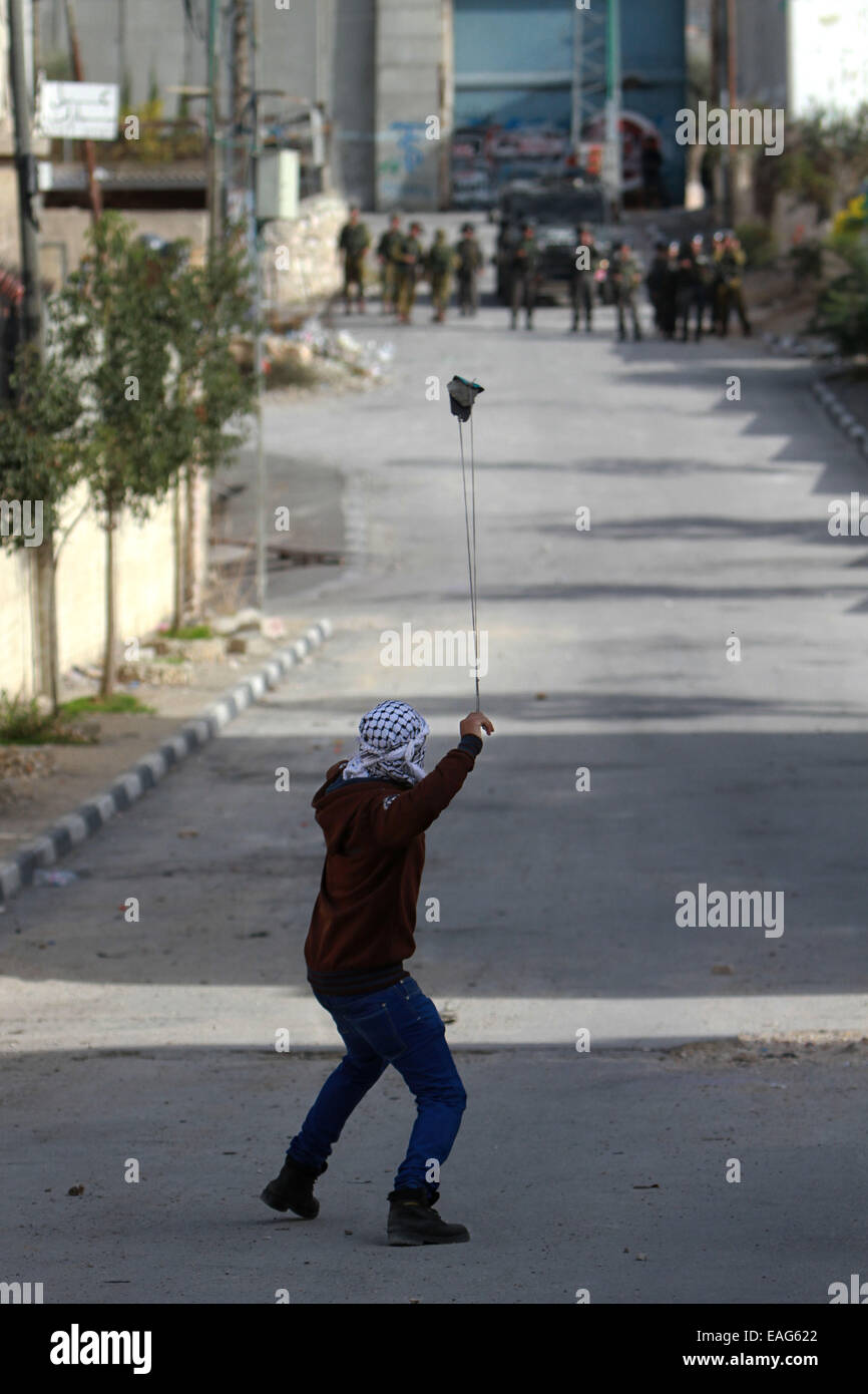 Bethleham. 14th November, 2014. A Palestinian young man hurls a stone ...