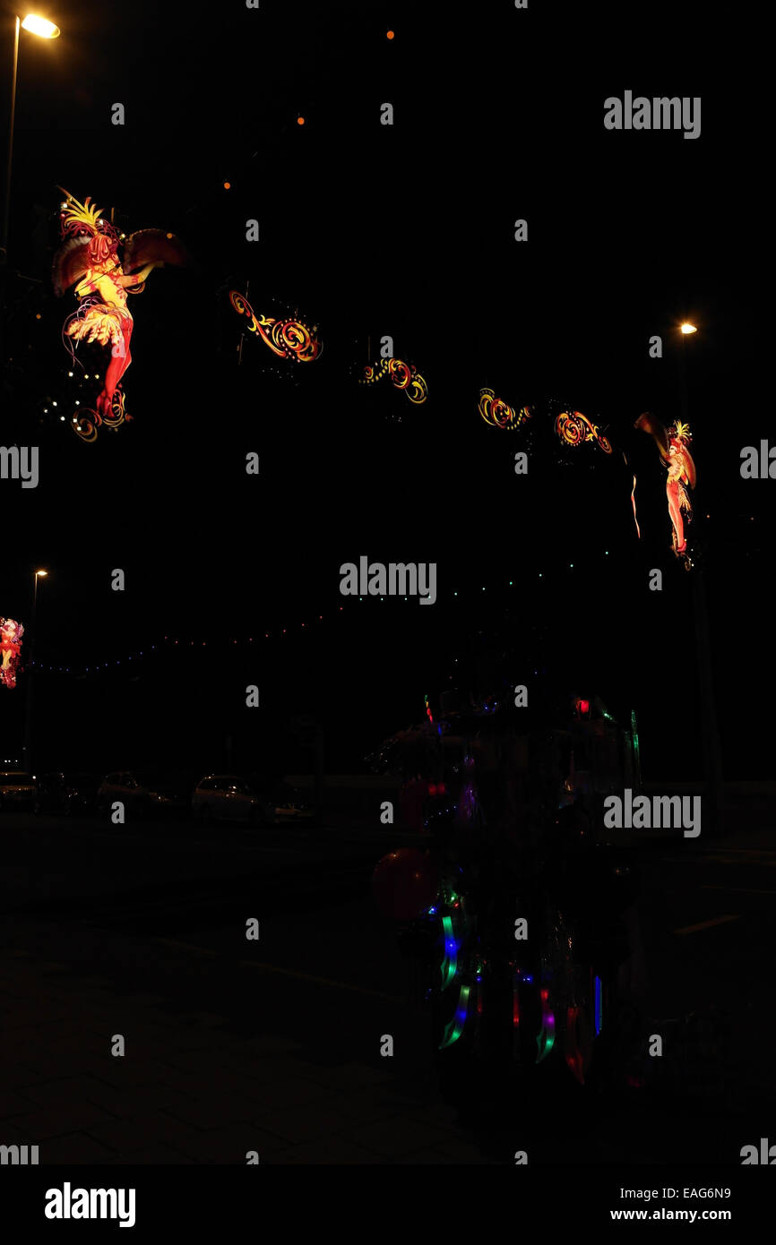 Oblique night portrait two red Decodance girls attached lamp-posts ...