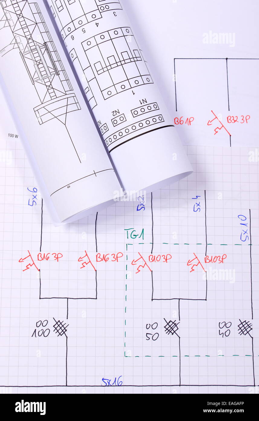 Rolls of electrical diagrams lying on construction drawings, drawings ...