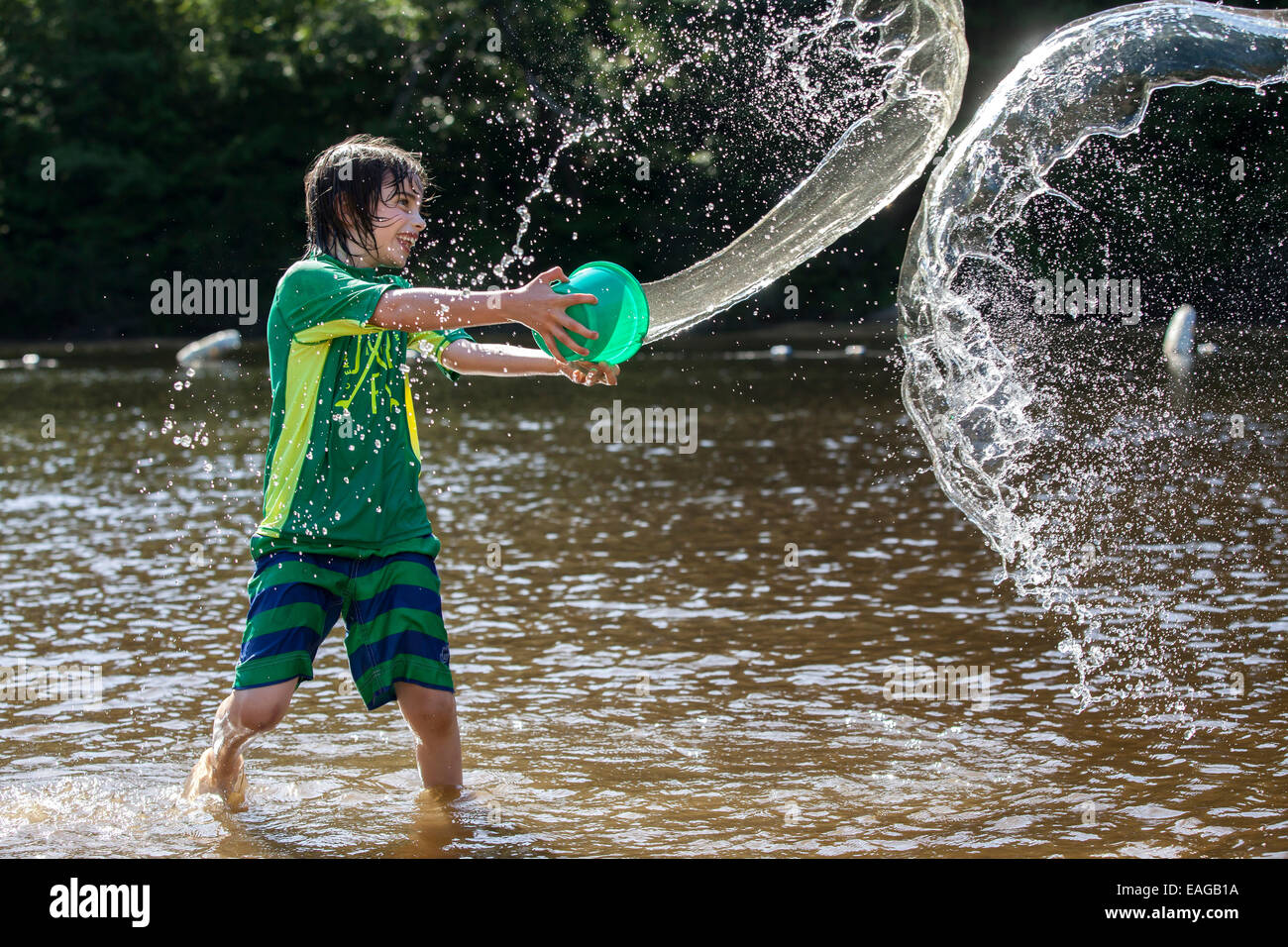 Young boy tossing water from bucket at Musante Beach Stock Photo - Alamy