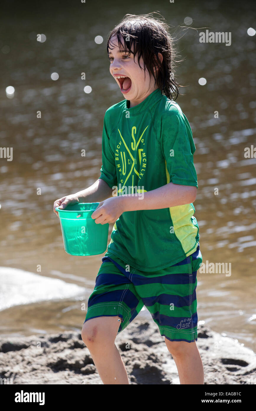 Young boy with bucket of water on Musante Beach Stock Photo - Alamy