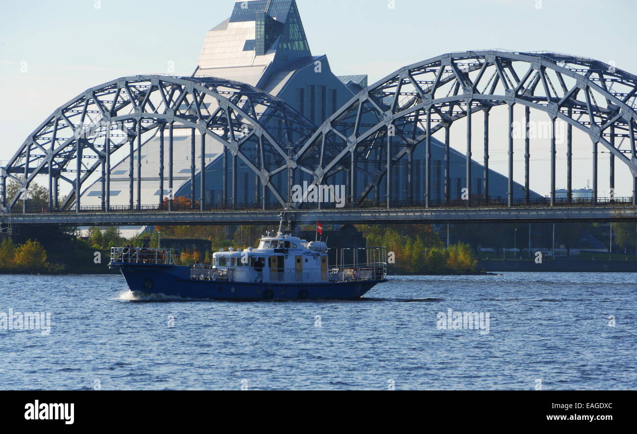 boat crossing railroad bridge and National Library in Riga Stock Photo ...