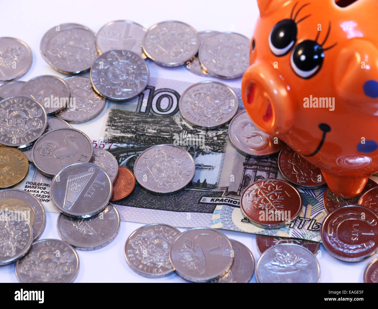 Bunch of Latvian lat coins and piggy bank on white background Stock ...