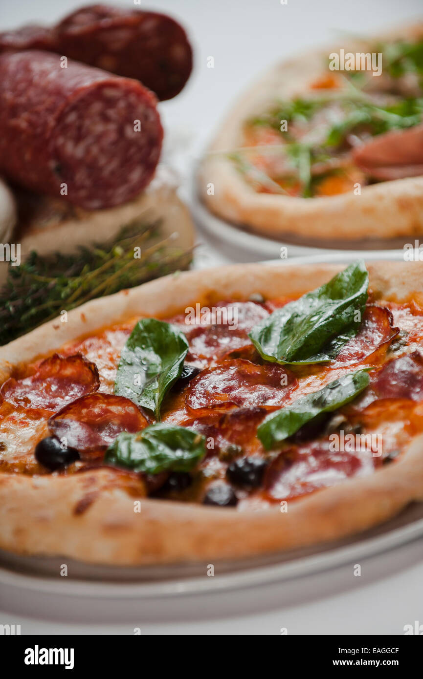 Italian Pizza with Salami Rocket and Basil Stock Photo - Alamy