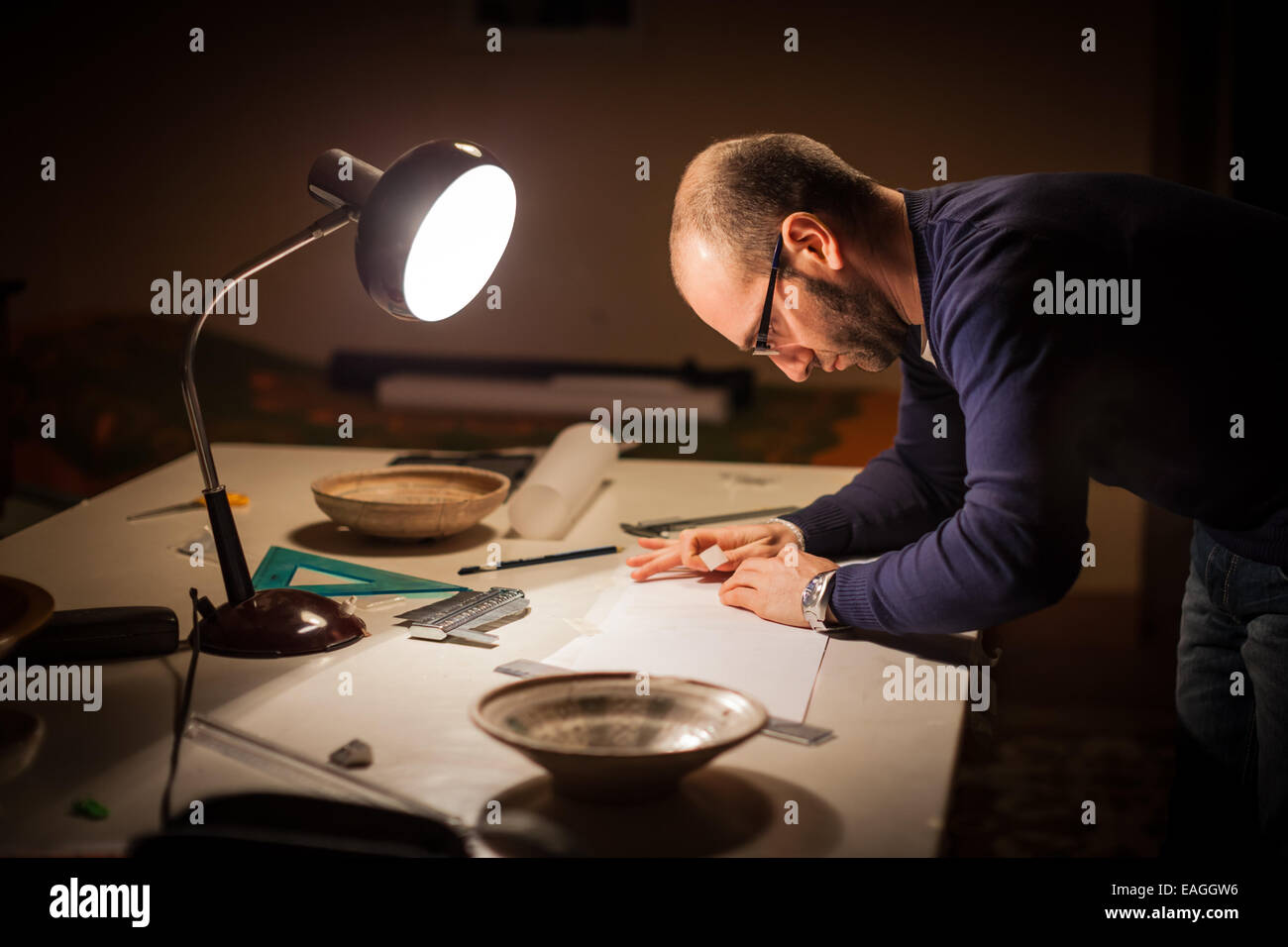 an archeologist examining some ancient crocks on a desk Stock Photo - Alamy