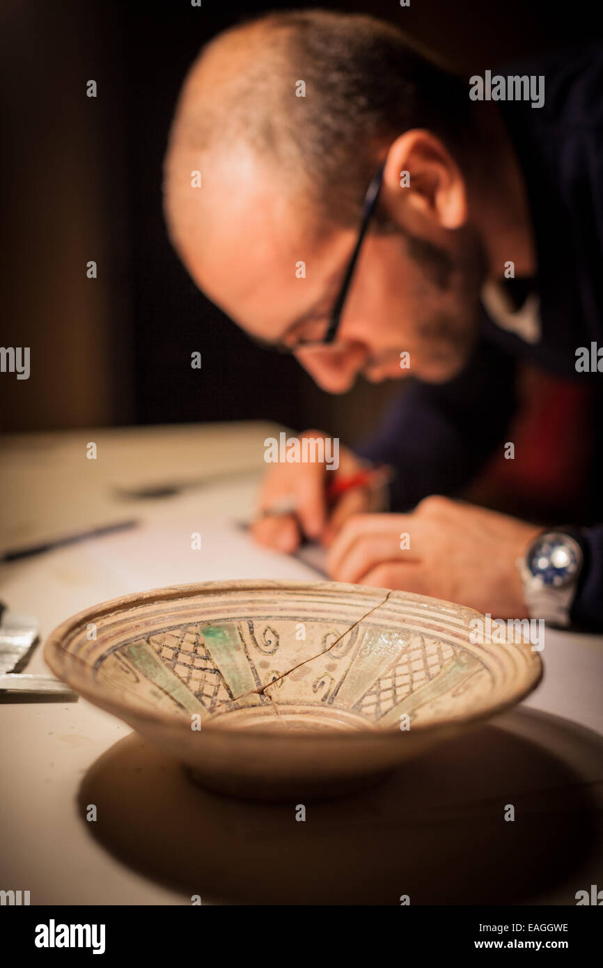 an archeologist examining some ancient crocks on a desk Stock Photo - Alamy