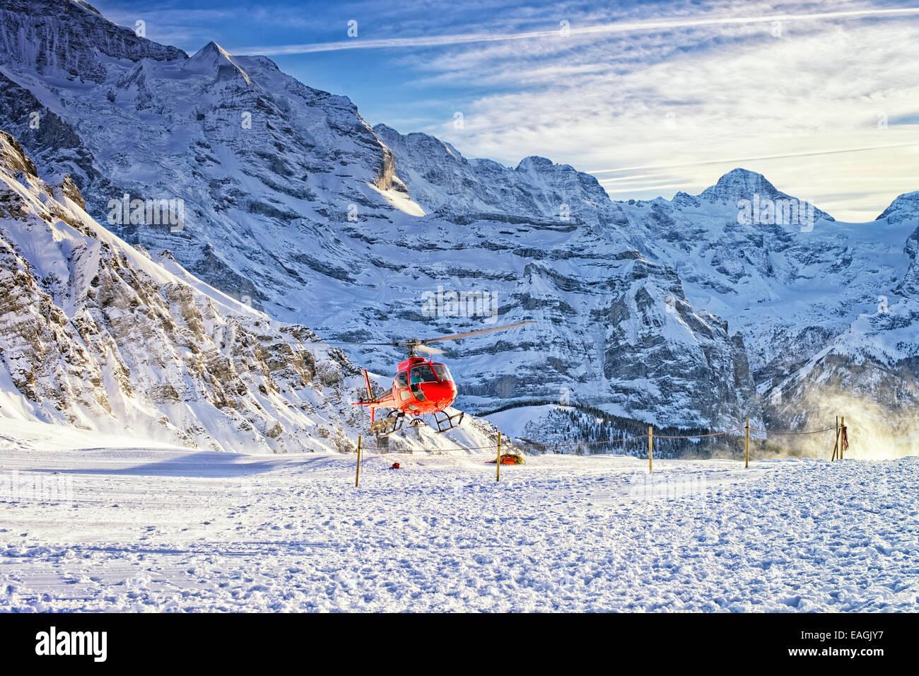 Red helicopter take off at swiss ski resort near Jungfrau mountain ...