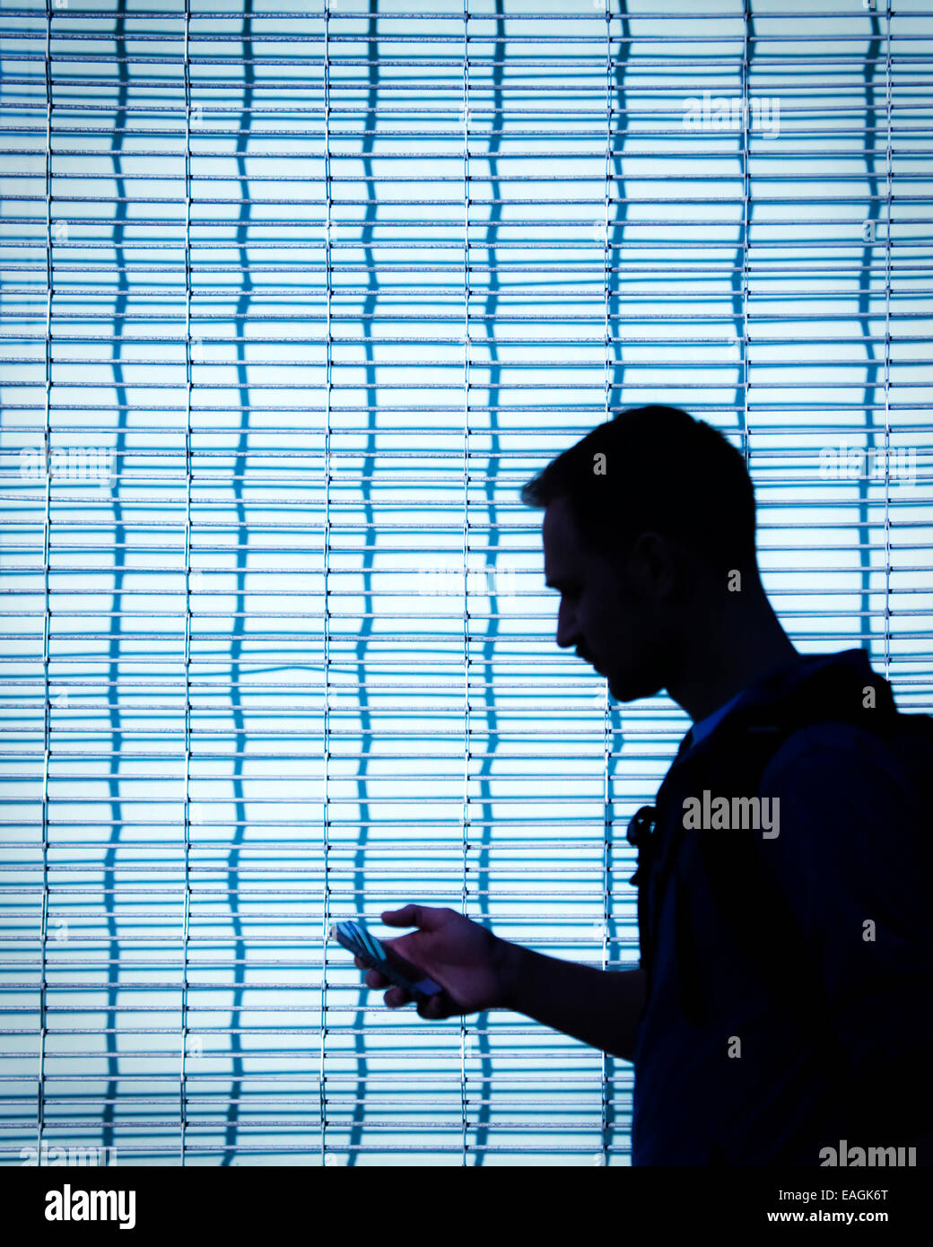 Silhouette of man looking at his hand holding device Stock Photo - Alamy