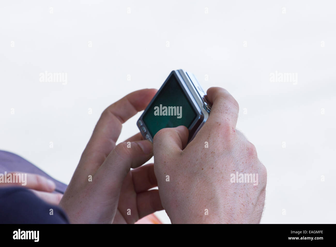 Closeup image of two hands holding black compact digital photo camera ...