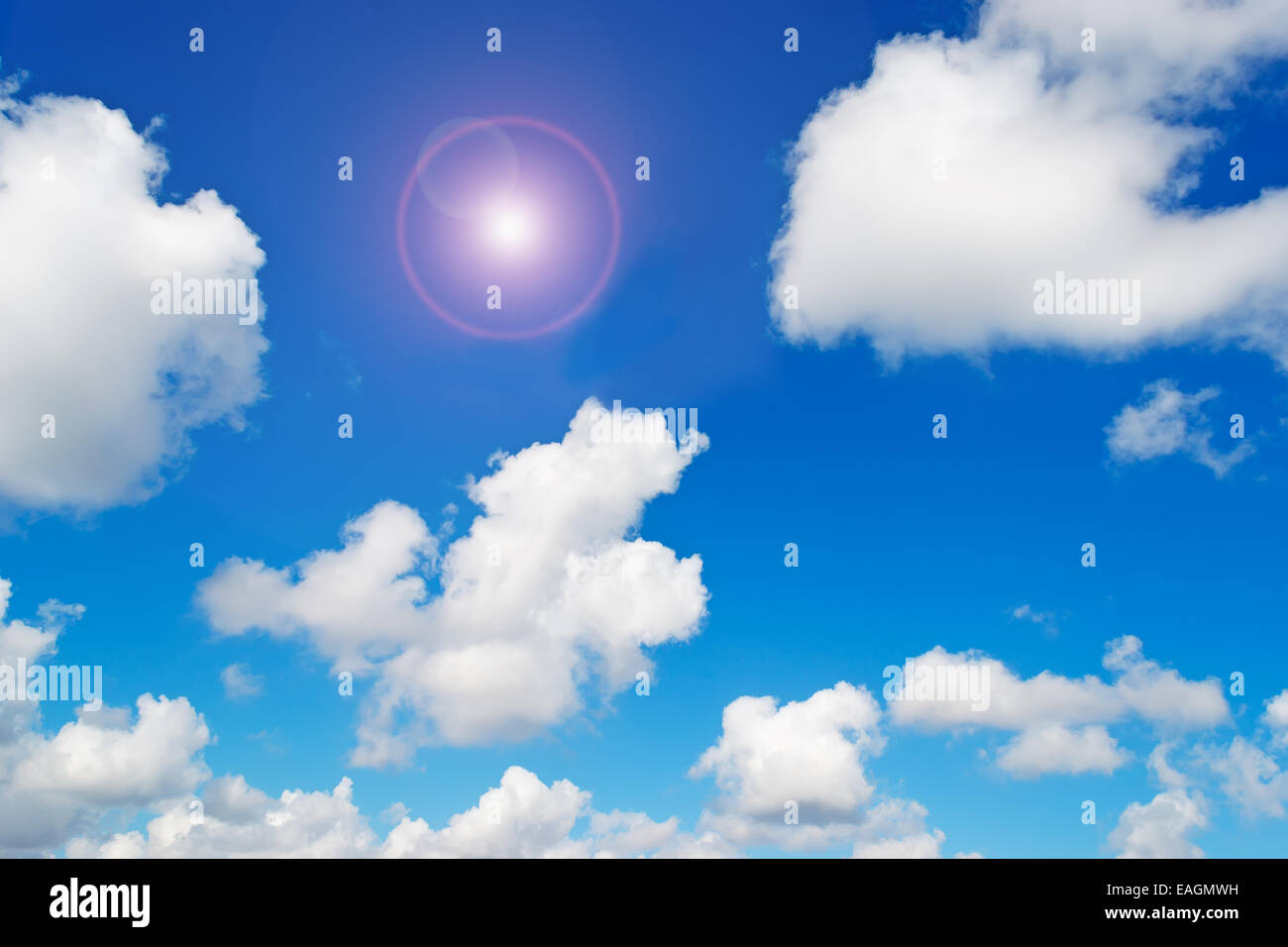 white, fluffy clouds in the sky with lens flare Stock Photo - Alamy