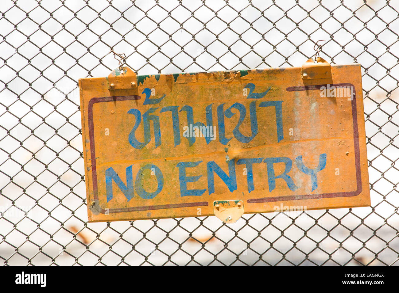 old no entry sign on mesh wire for fencing background. Thai language ...