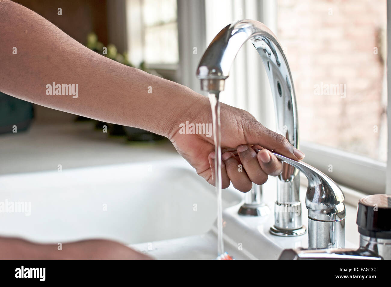 A hand operates a faucet Stock Photo - Alamy