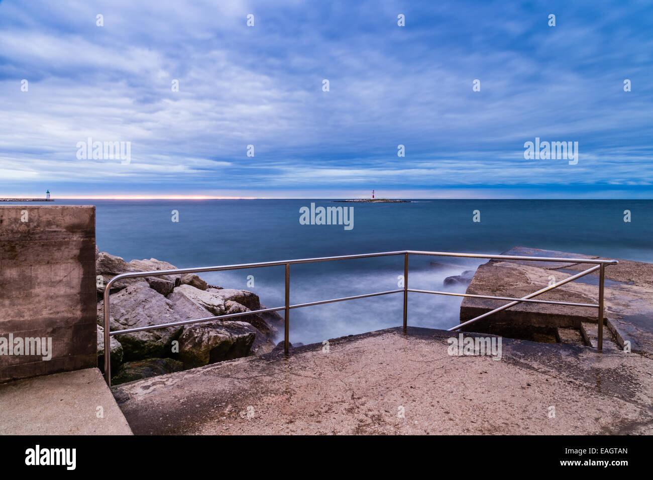 Sunset on breakwater with stairs on the Mediterranean sea with red ...