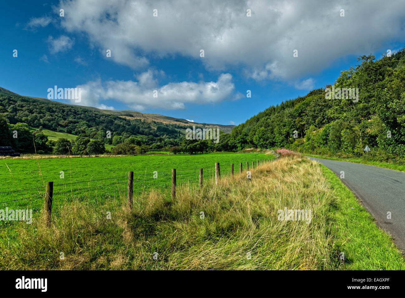 Quite country road leading to the head of the valley, with a fenced off ...