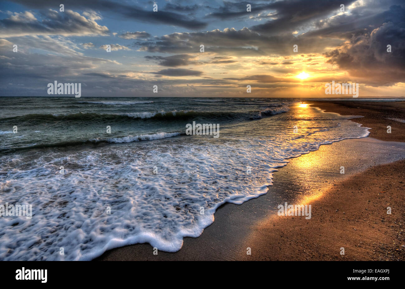 Beautiful sunset and waves on the beach Stock Photo - Alamy