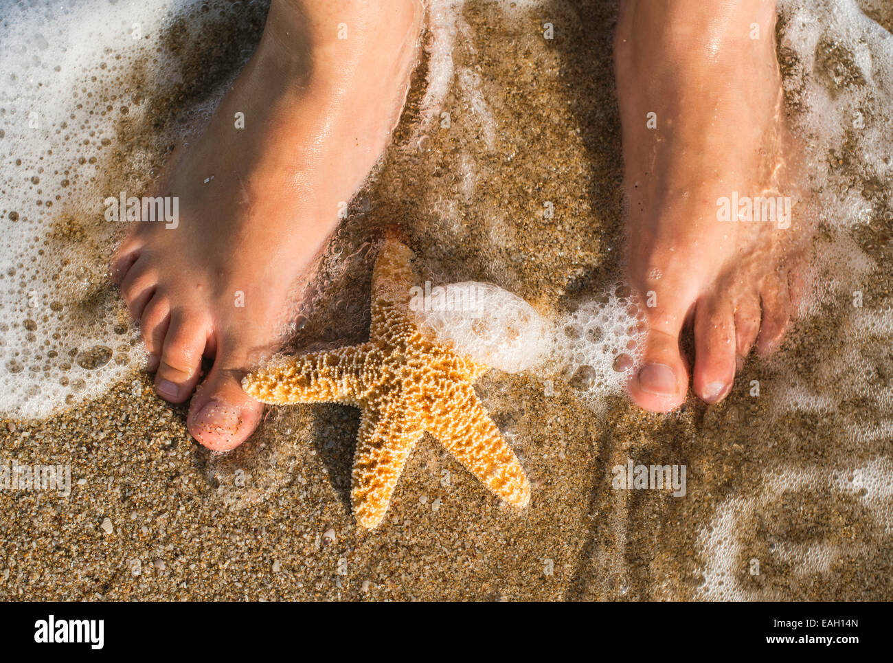 Starfish and feet on the beach. Sea waves Stock Photo - Alamy