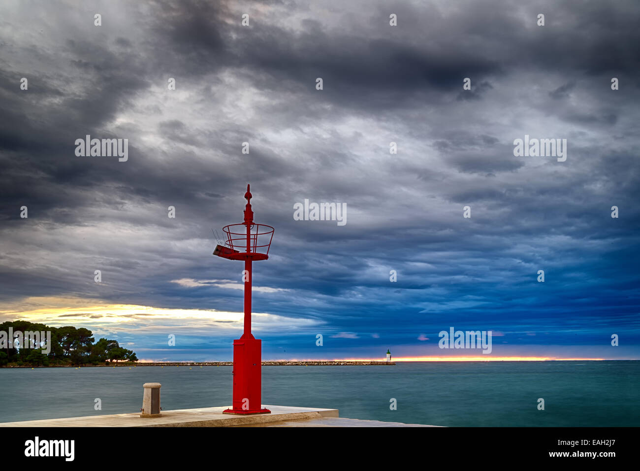 Sunset on docks on the Mediterranean sea with red steel look-out post ...