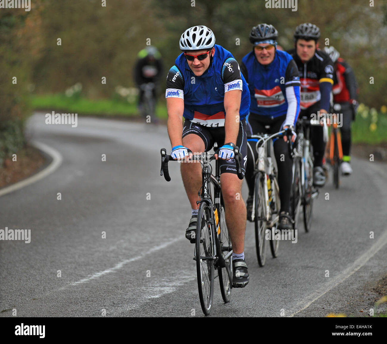 Cyclists riding along a road in a line Stock Photo - Alamy