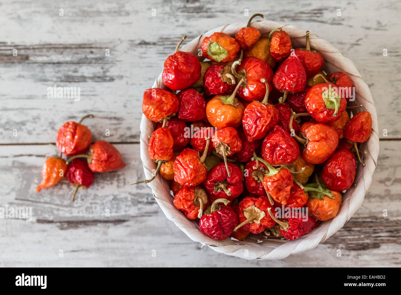 Red Hot Cherry Peppers in rattan bowl over white wooden background ...