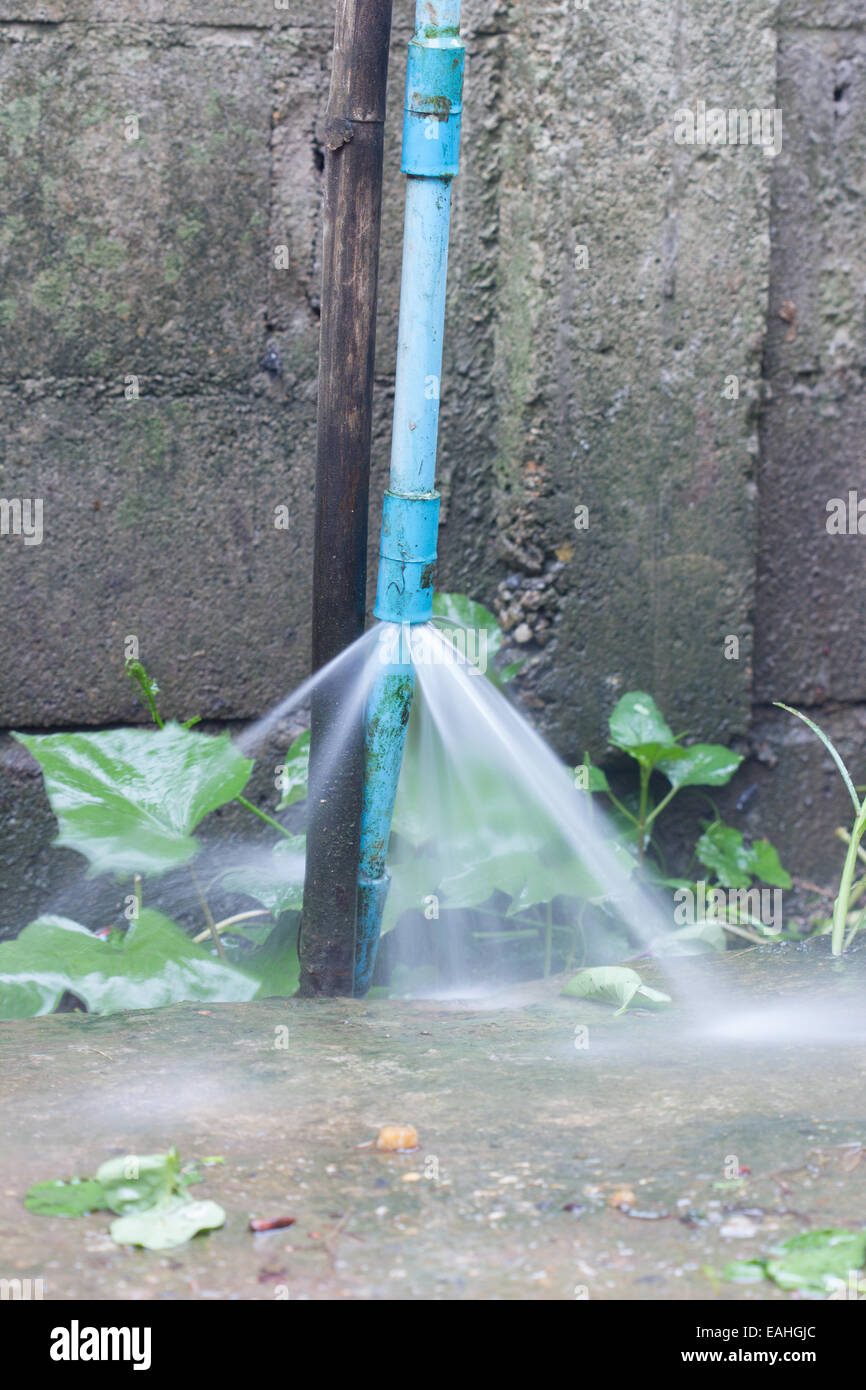 Old rusty pvc pipe with leak and water spraying out Stock Photo - Alamy
