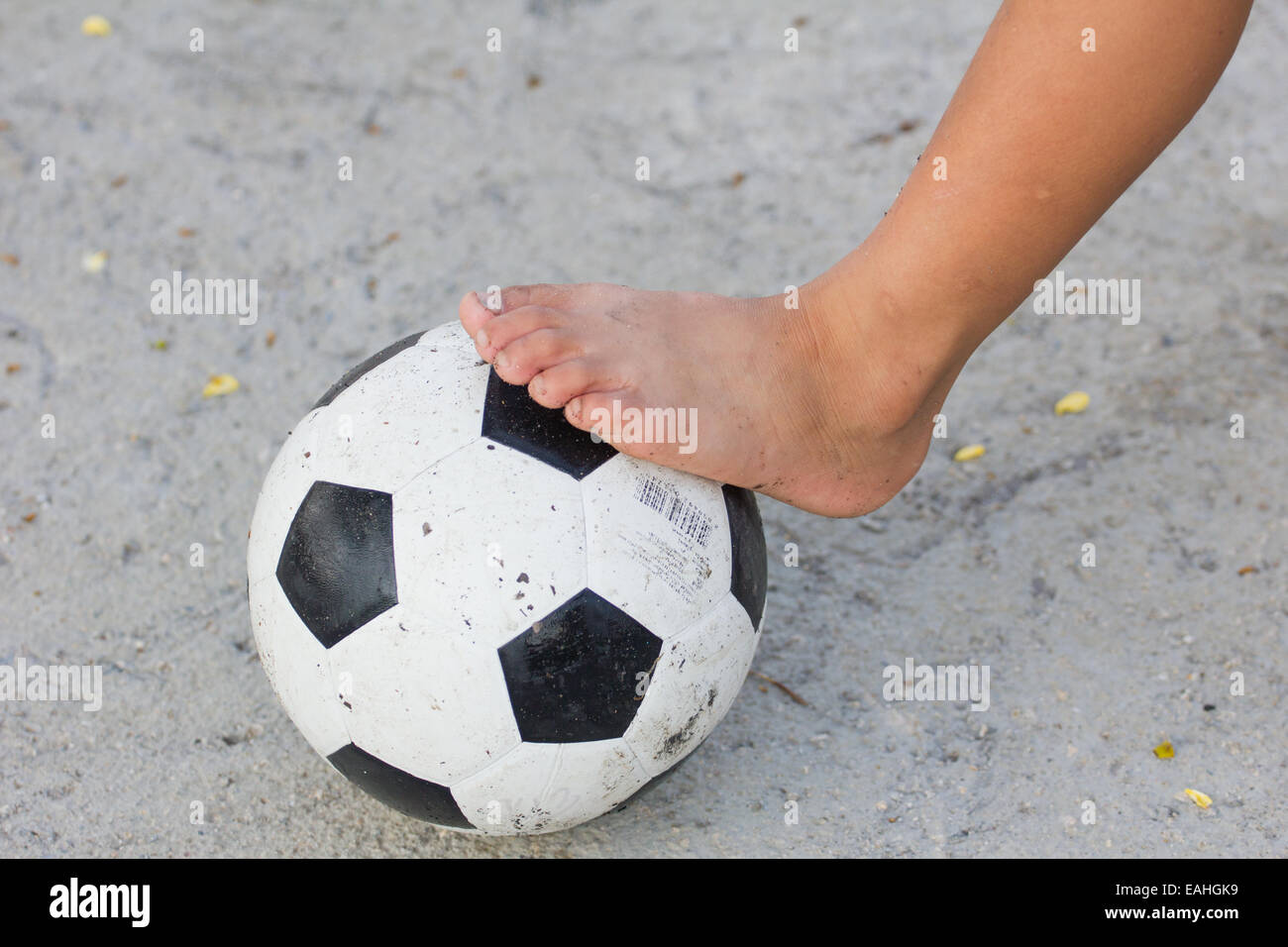 close up of foot of a boy treading on soccer on concrete field Stock ...