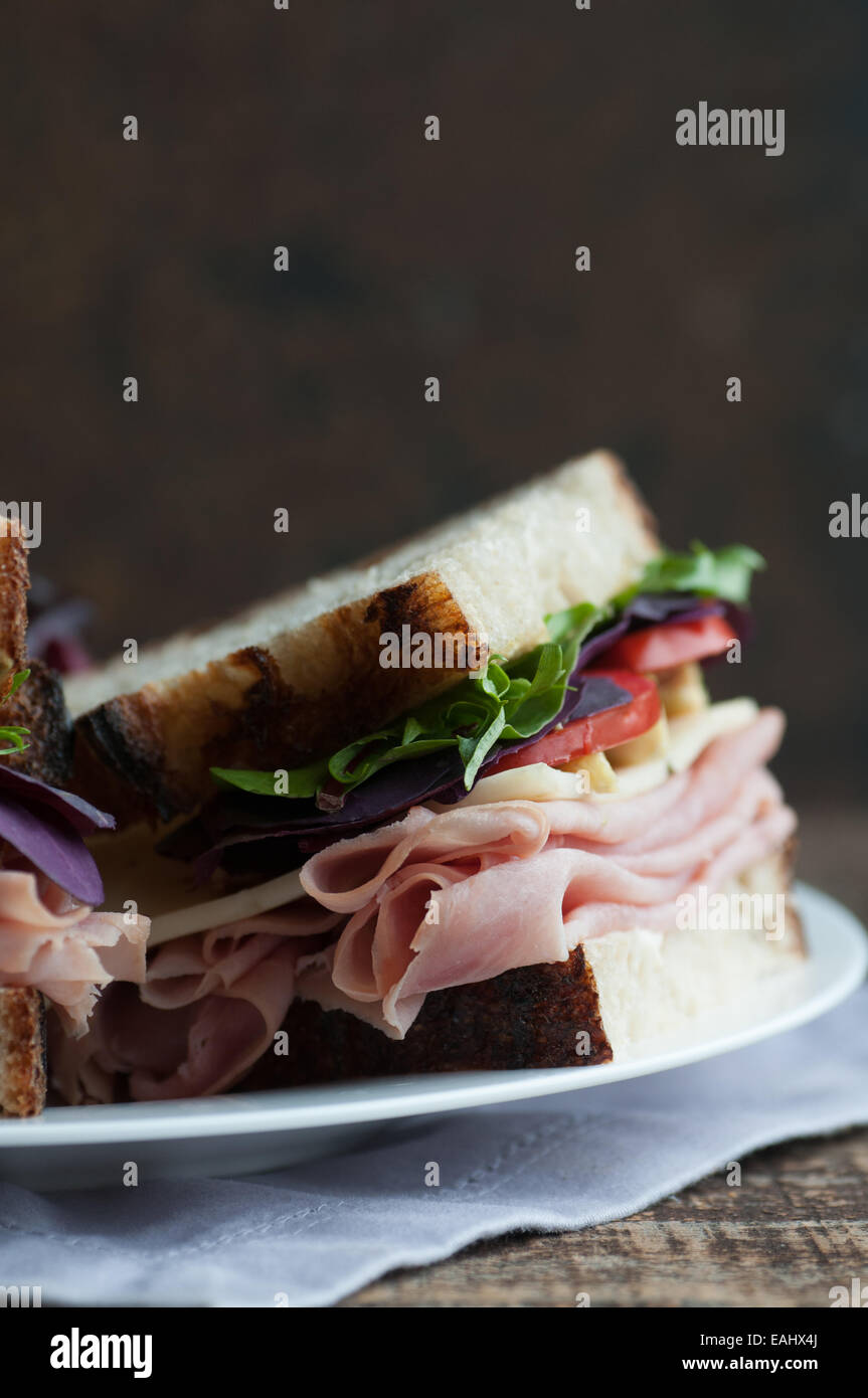 Thin sliced ham and vegetables on rustic crusty fresh country bread ...