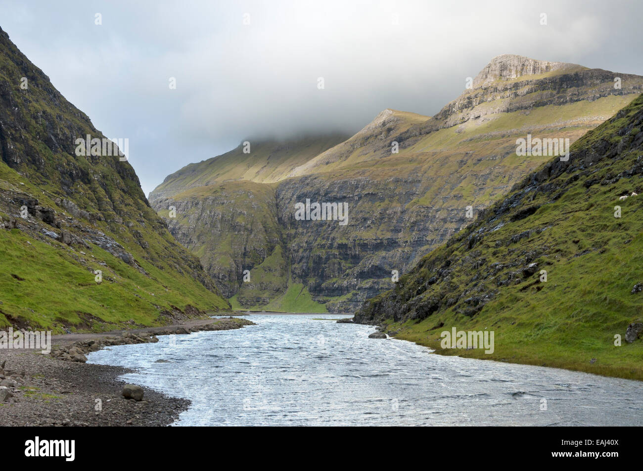 A small fjord surrounded by green steep slopes, Faroe Islands Stock ...