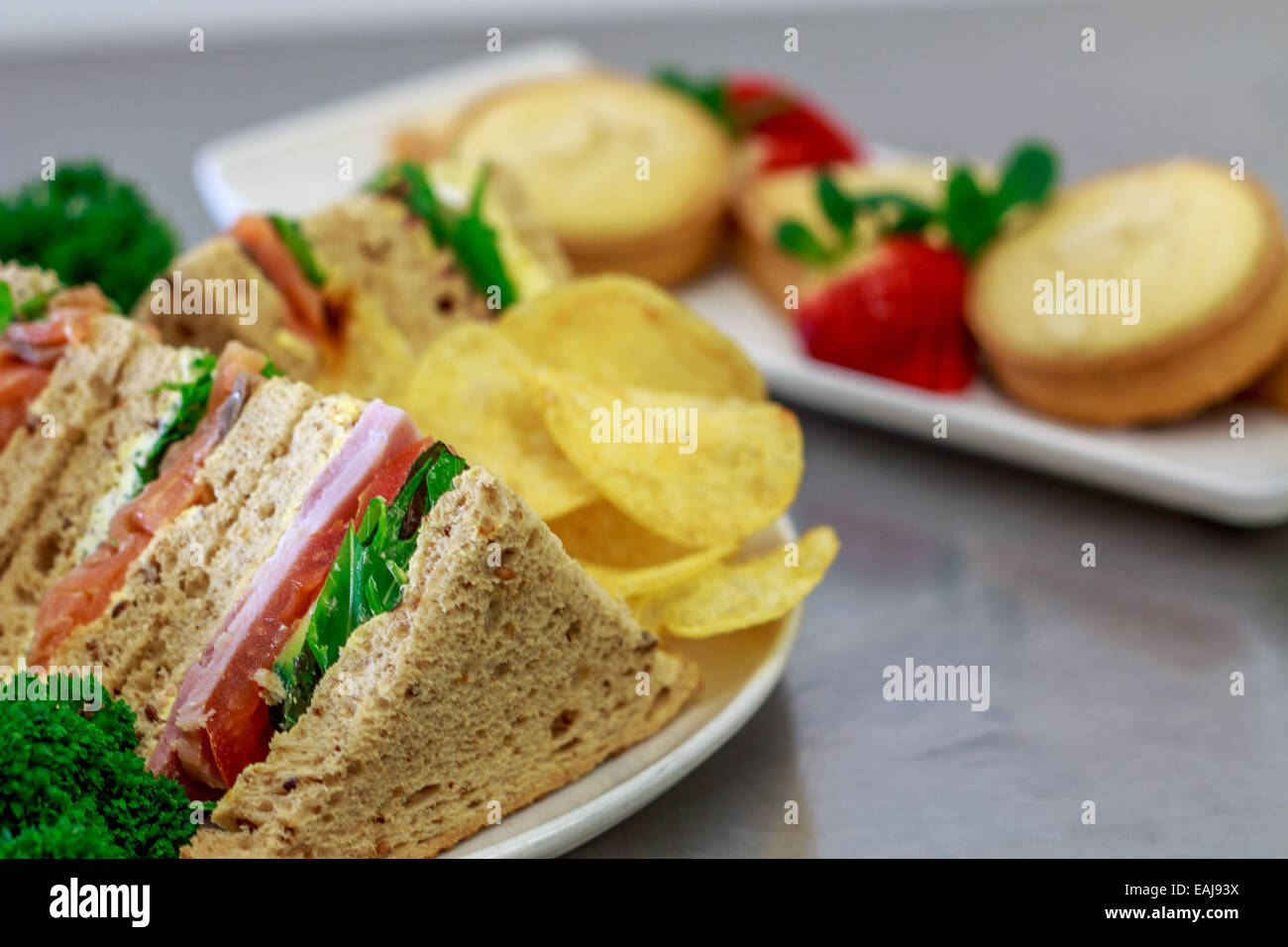 plated buffet lunch with a selection of sandwiches fruit baked sweets ...