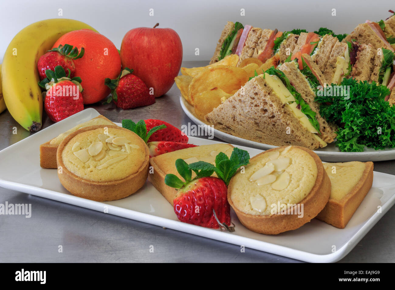 plated buffet lunch with a selection of sandwiches fruit baked sweets ...