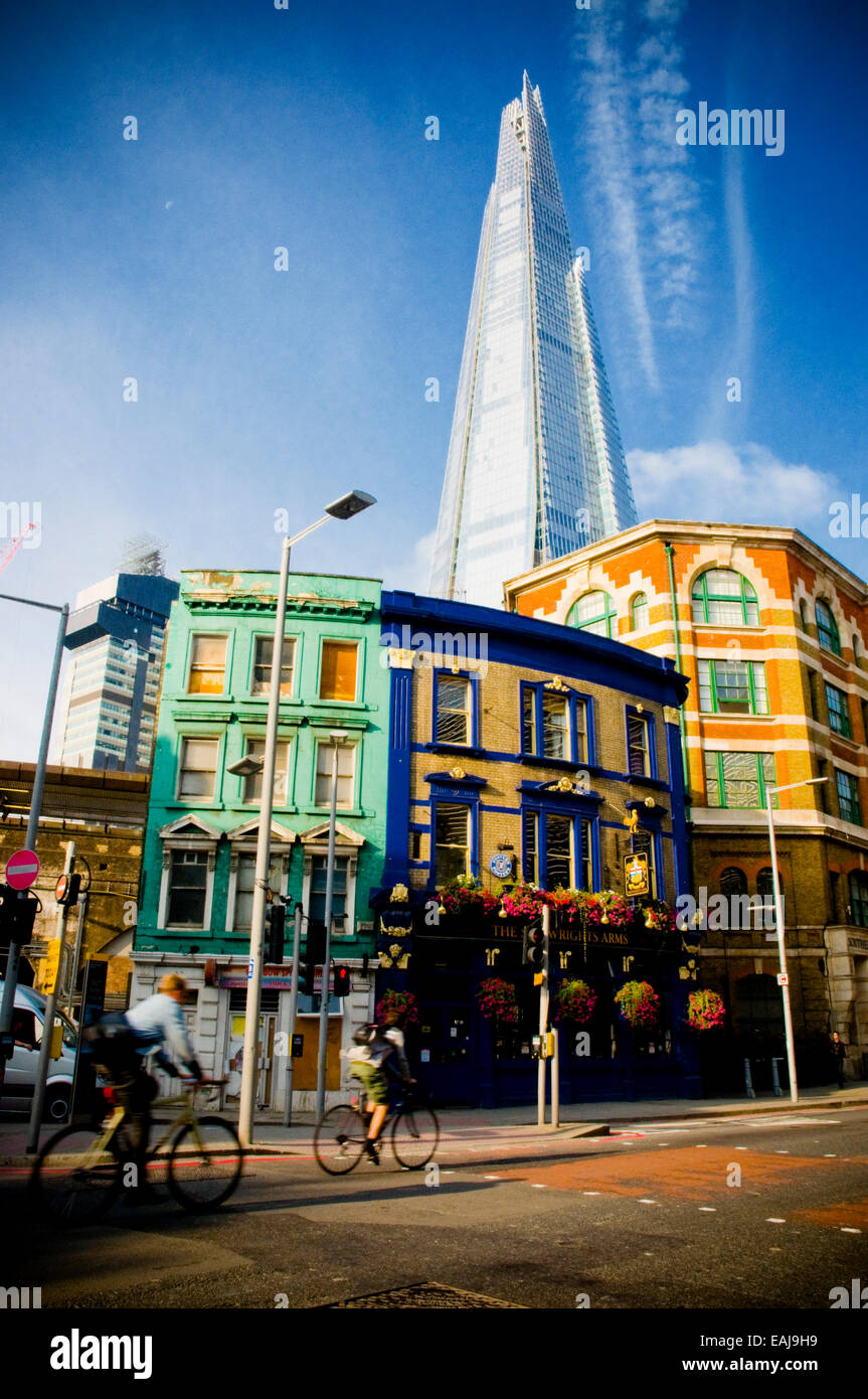 Cyclists commute past old buildings and the Shard in London, UK Stock ...